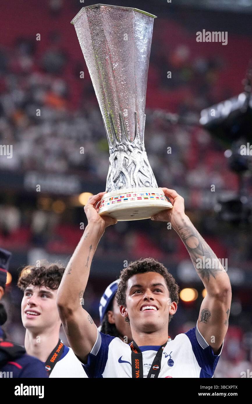 Tottenham's Brennan Johnson lifts the trophy as they celebrate after ...