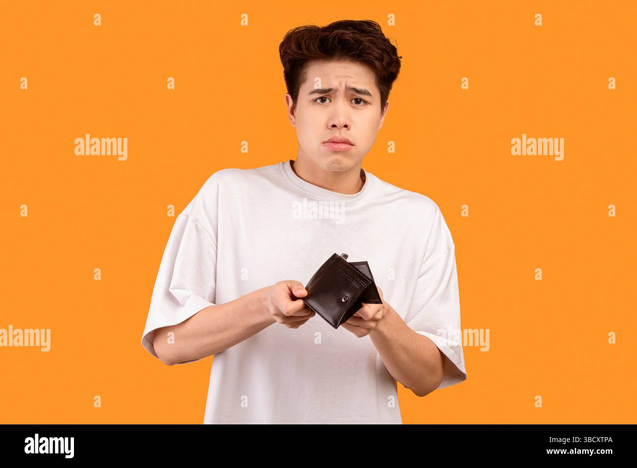 Portrait of asian guy showing his empty wallet Stock Photo - Alamy