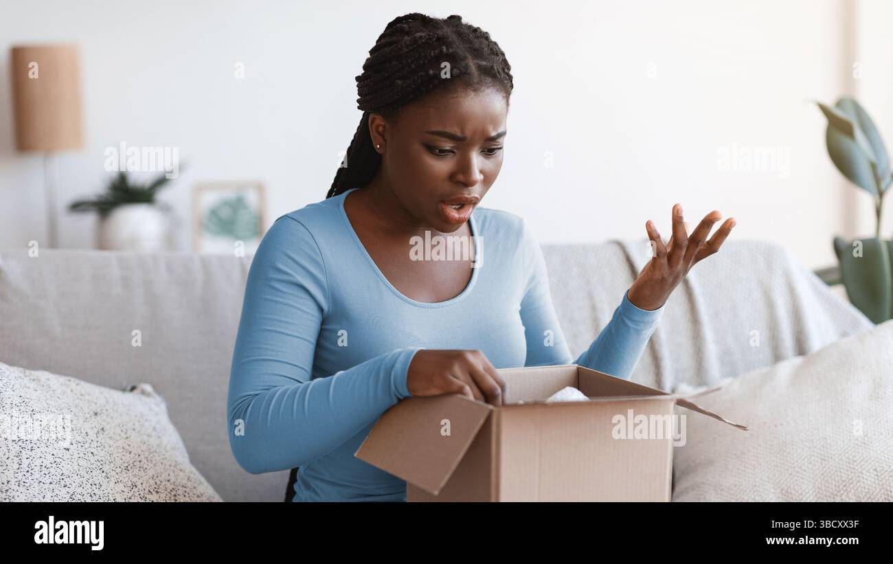 Wrong Parcel. Shocked frustrated black woman unpacking box, suffering ...