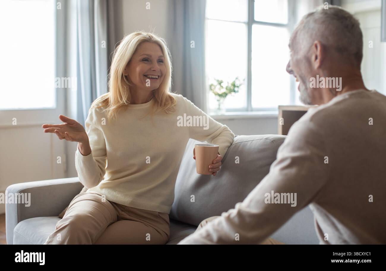 Happy couple sharing a light conversation on a cozy sofa in natural ...