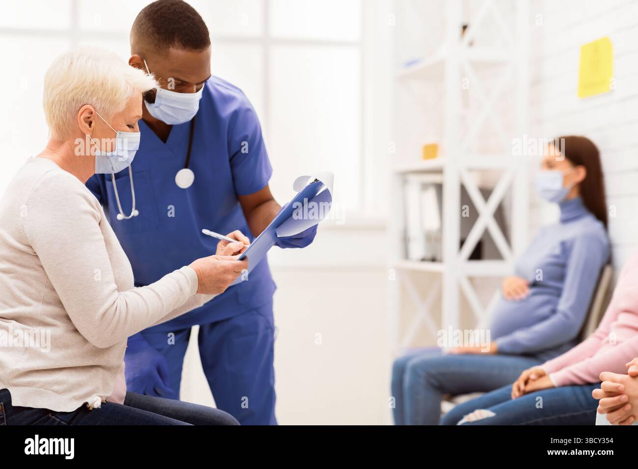 Mature Patient Lady Signing Papers With Doctor In Hospital Waiting-Room ...