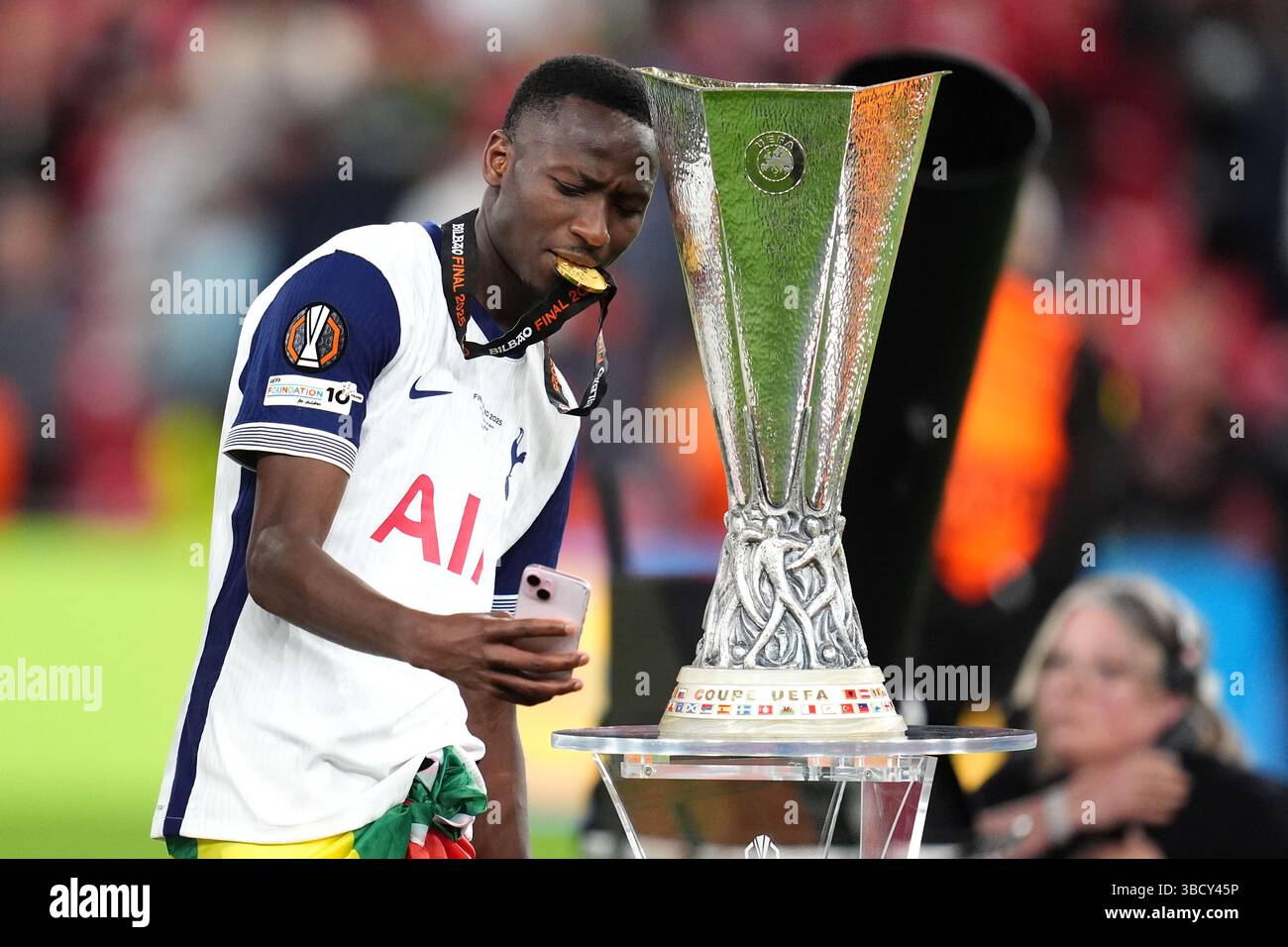 Tottenham Hotspur's Pape Matar Sarr takes a photo with the trophy after ...