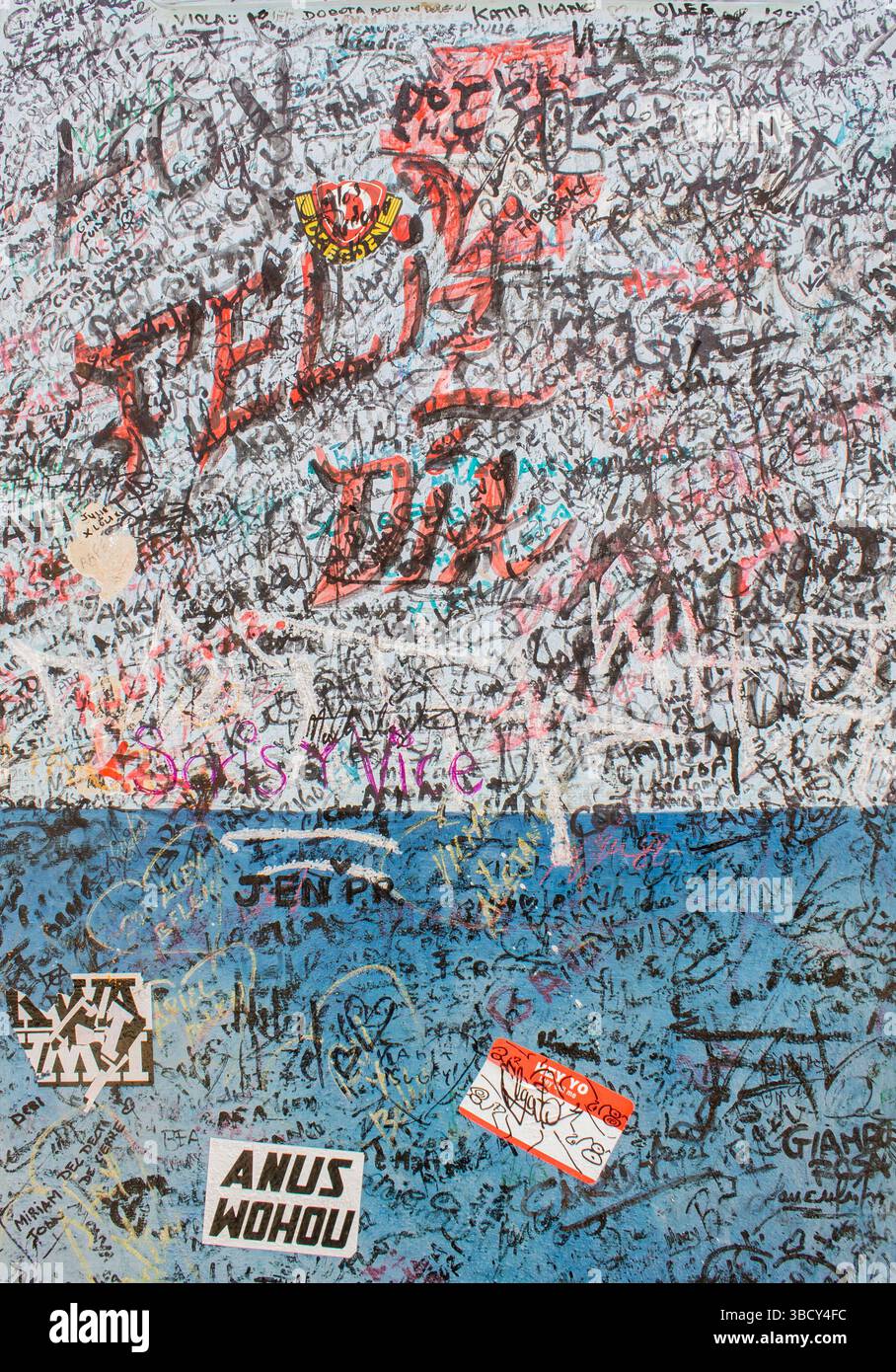 Urban wall covered in layers of diverse graffiti, street art, and ...