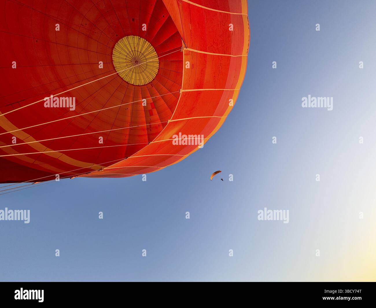 Hot air balloon ride, Paraglider with motor passes the hot air balloon ...