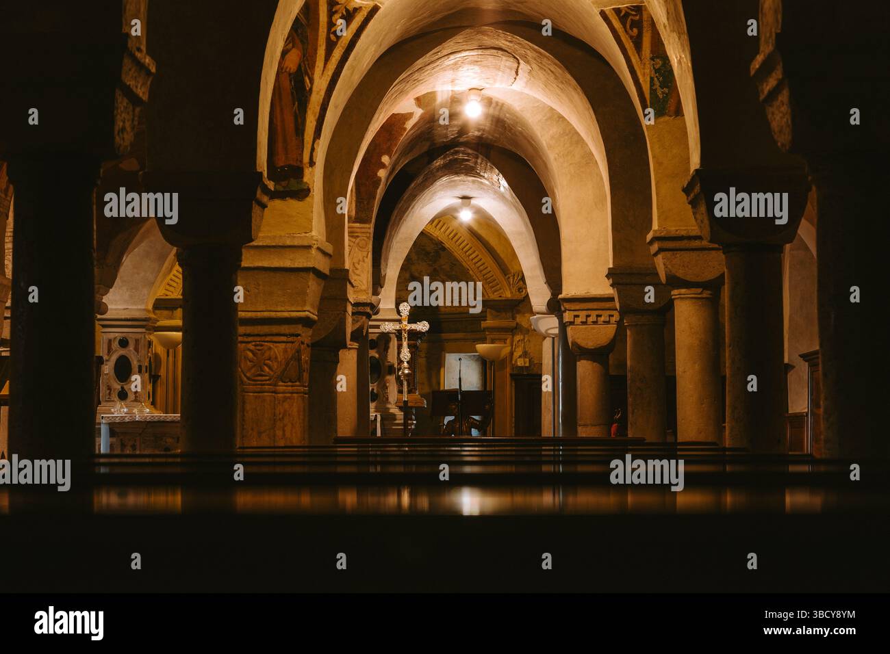 Warm interior of the crypt of the Cathedral of Treviso with arches ...