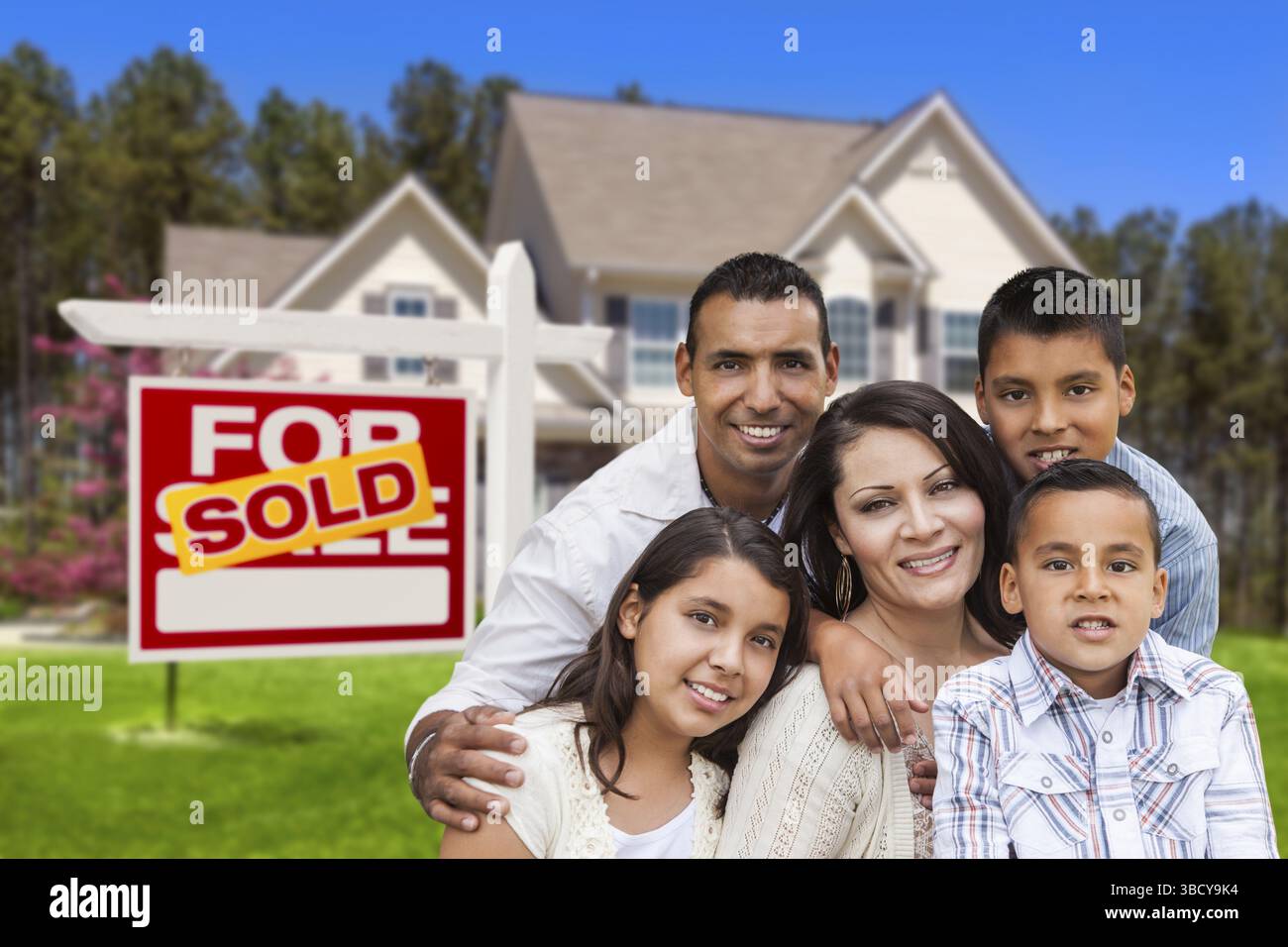 Happy hispanic family in front of their new house and sold home for ...
