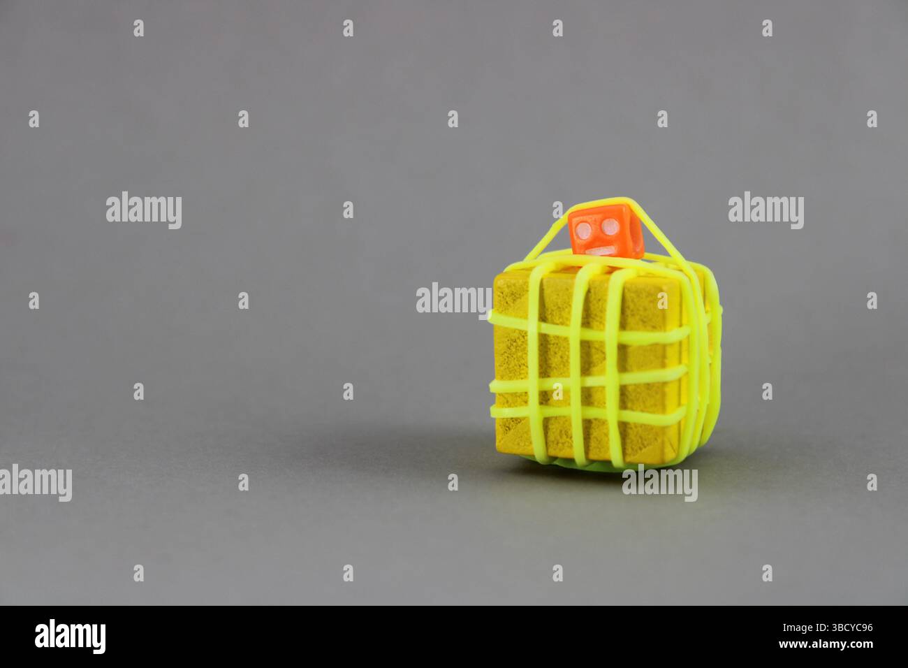 Cube with a sad face trapped with a rubber band Stock Photo - Alamy