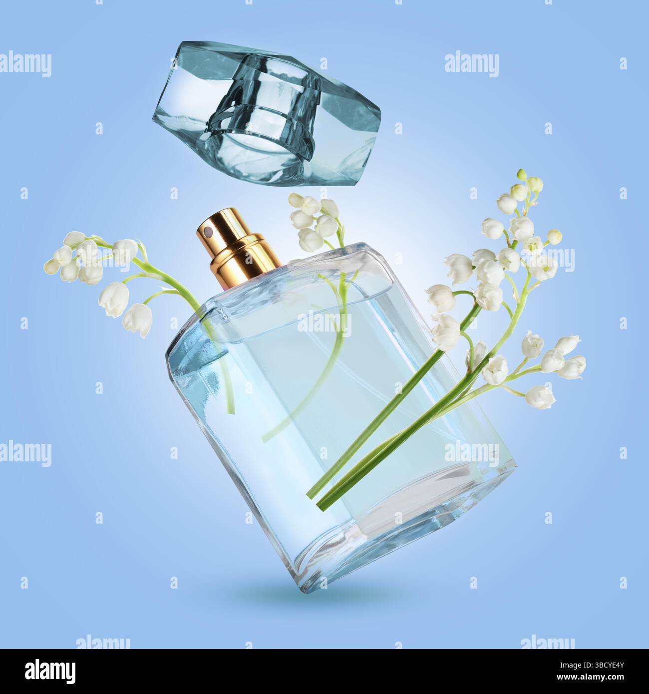 Lilies of the valley and bottle of perfume in air on light blue ...