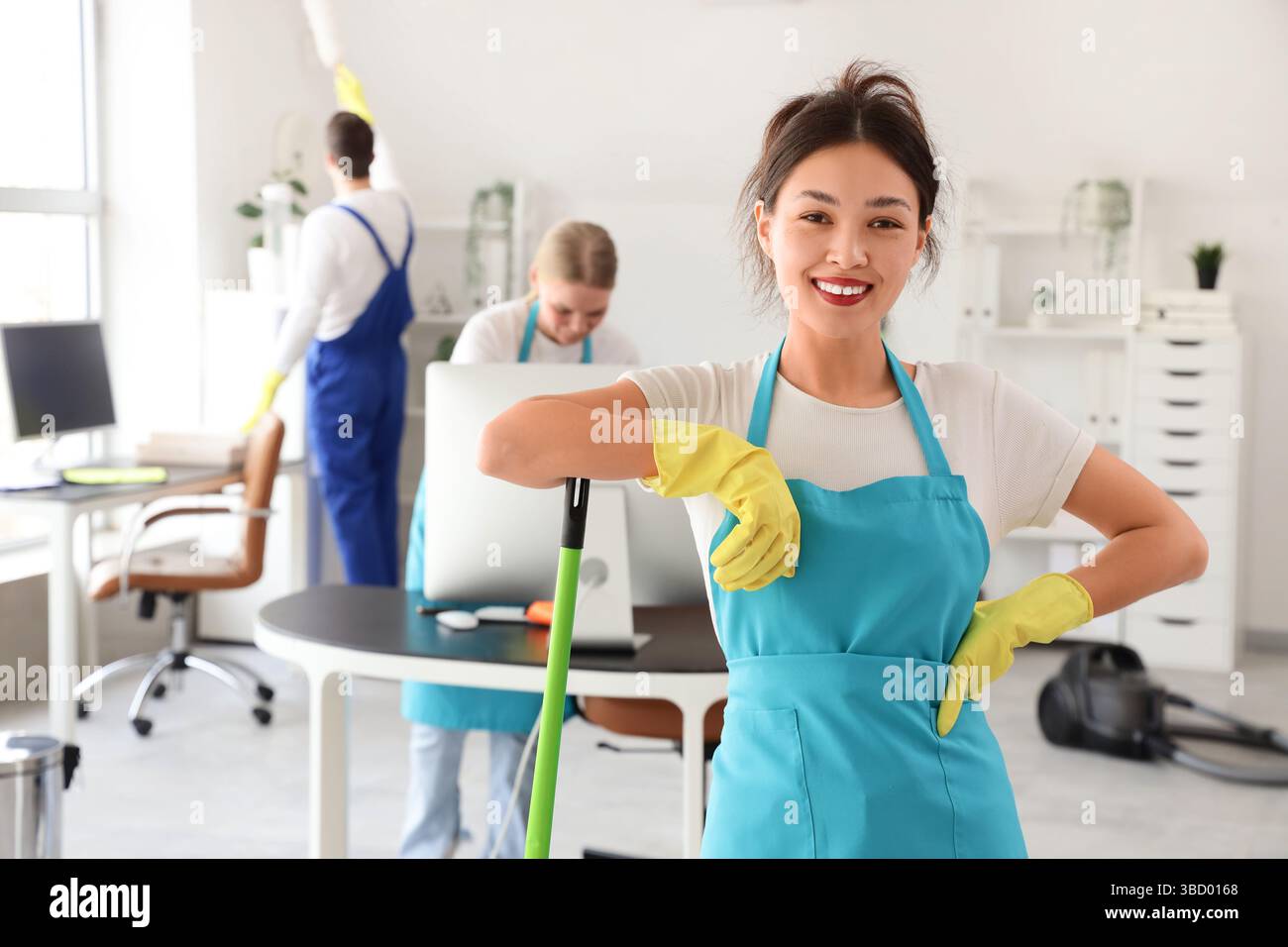 Female Asian janitor with mop in office Stock Photo - Alamy