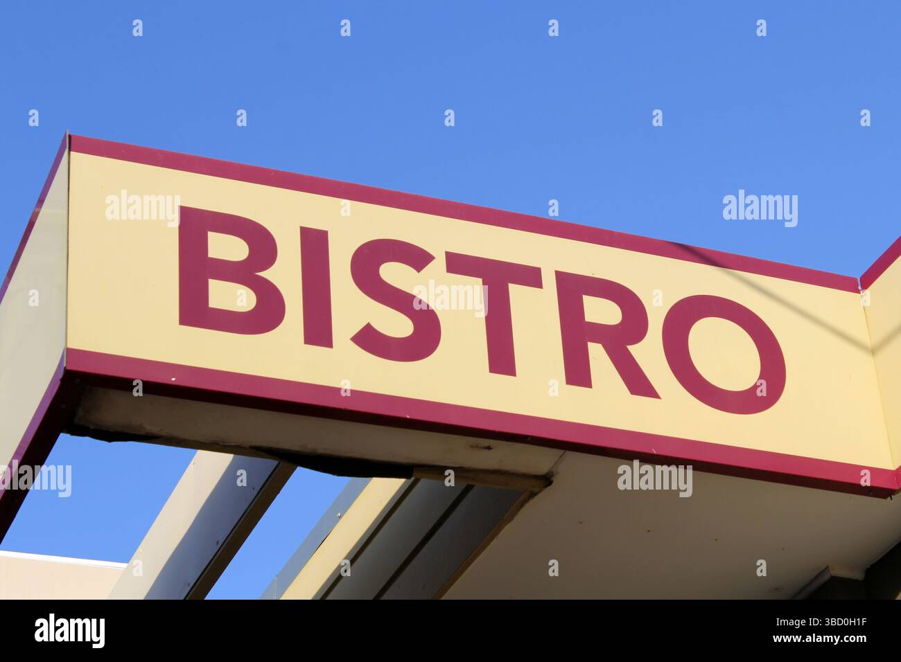 Bistro sign on the exterior of a restaurant building with a blue sky ...
