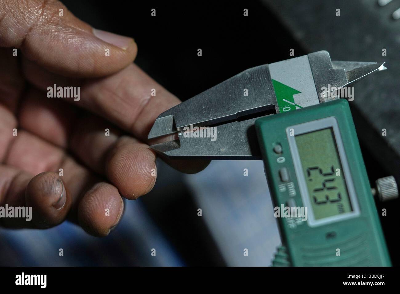 A diamond trader measures a diamond using a vernier caliper in Surat ...