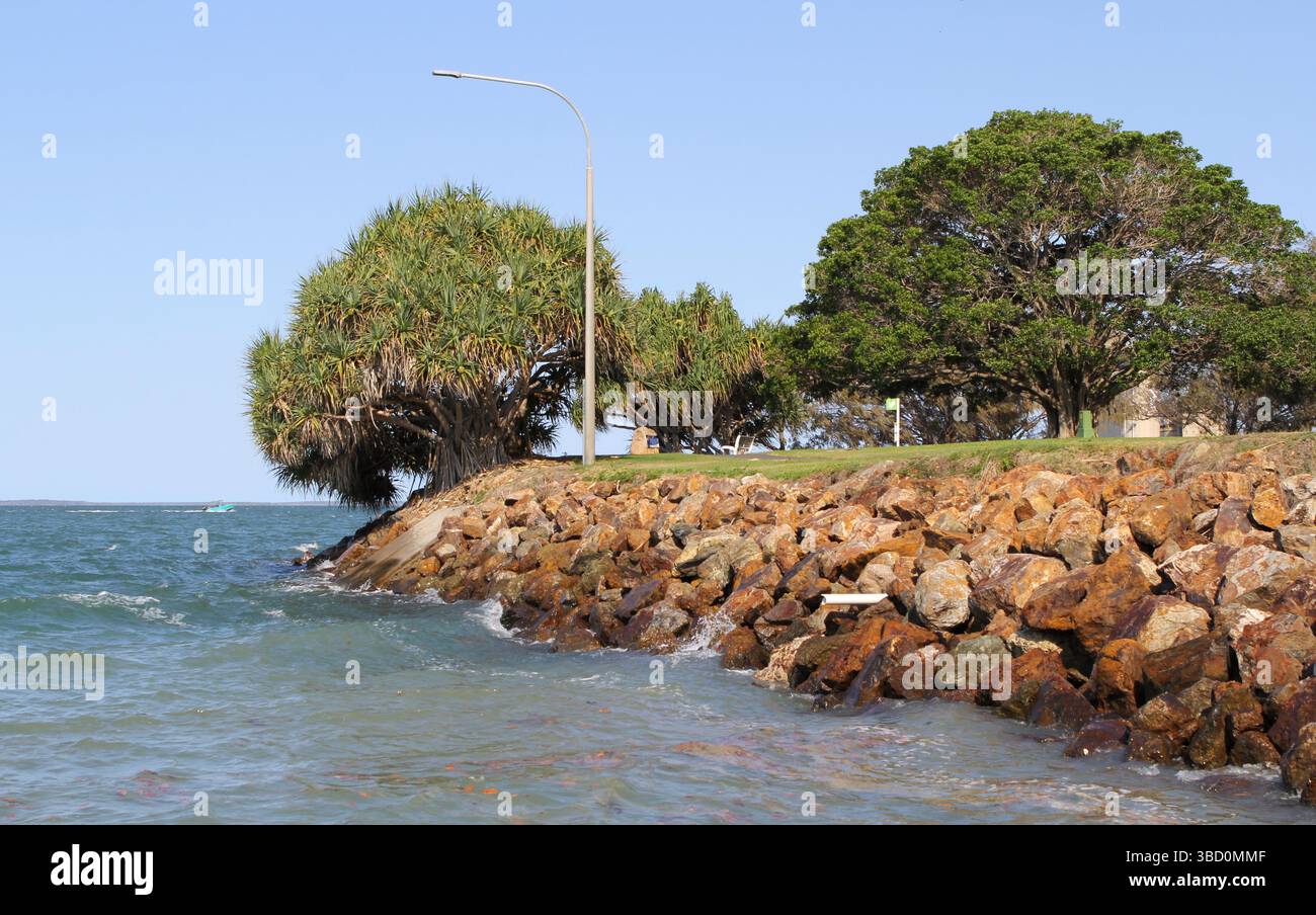 Ocean water, rocks and trees at Spinnaker Park in Gladstone, Queensland ...