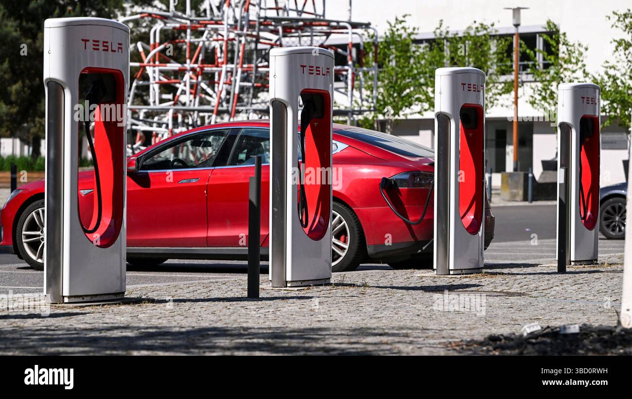 Berlin, Germany. 20th May, 2025. A Tesla car charges at a Tesla ...
