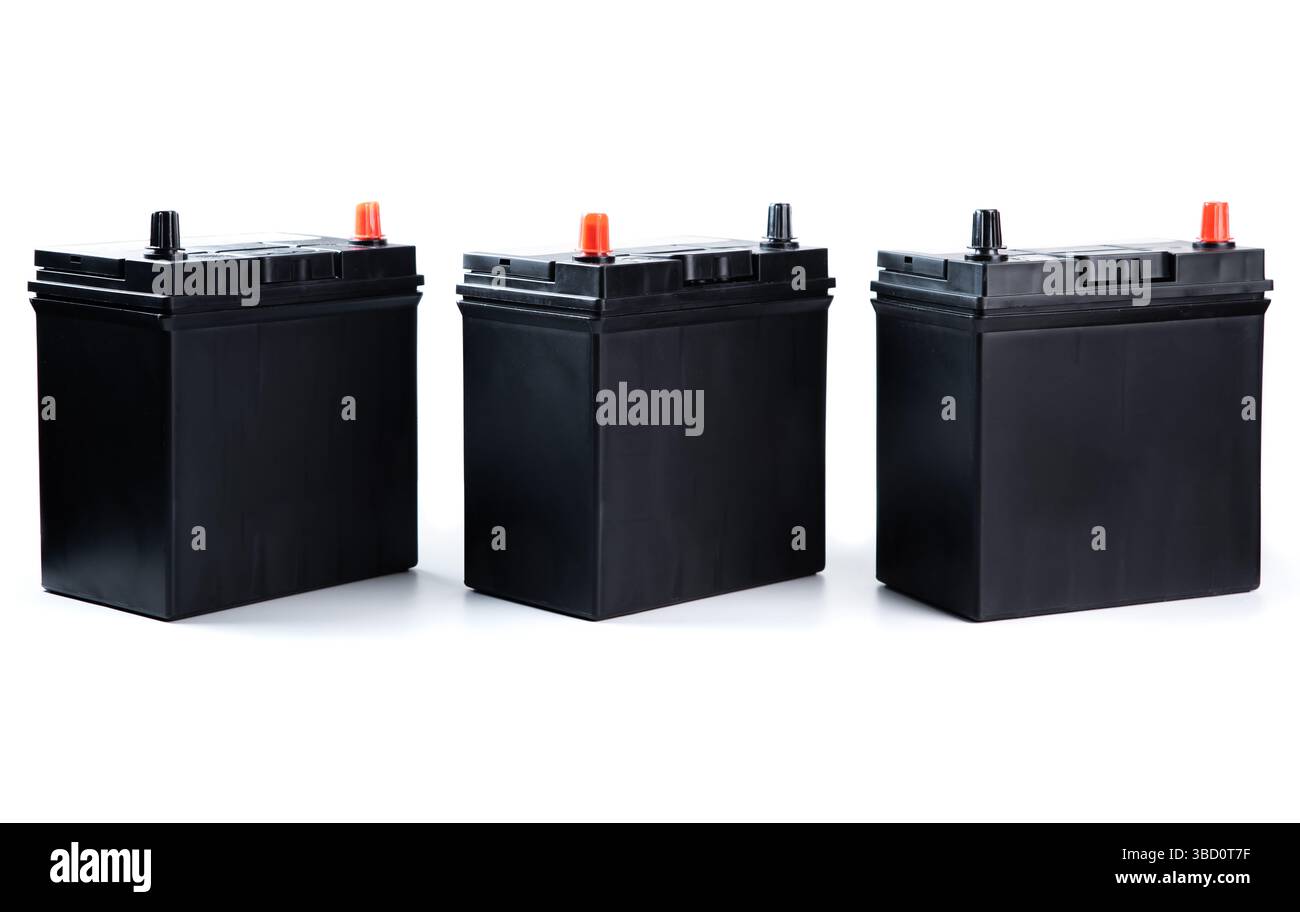 Row of three matching automotive batteries isolated on white background ...