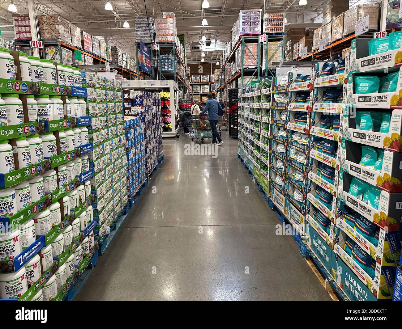 Shoppers push their carts amid displays of goods in a Costco warehouse ...