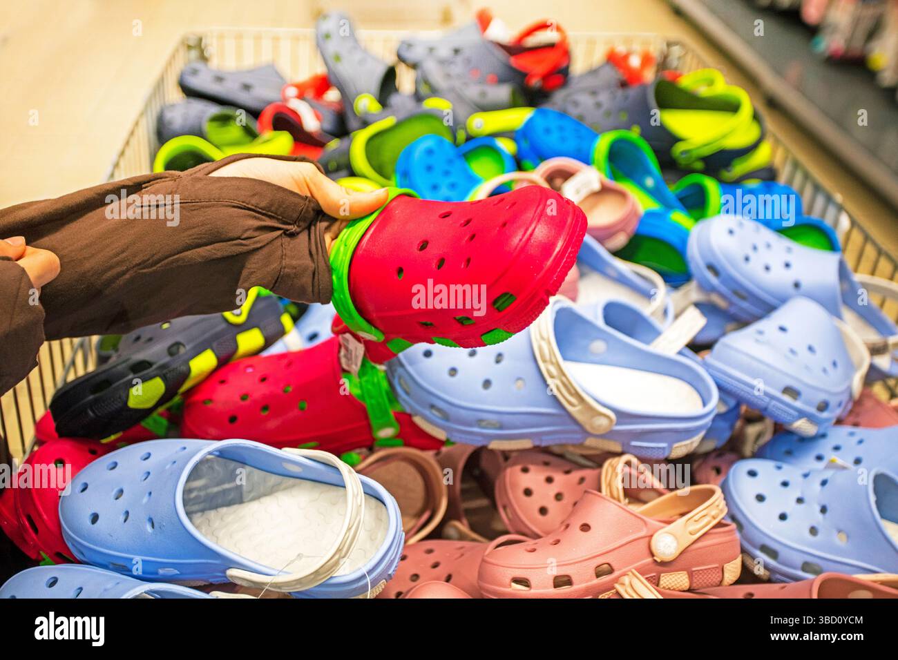 choosing summer rubber crocs in a container in a supermarket Stock ...