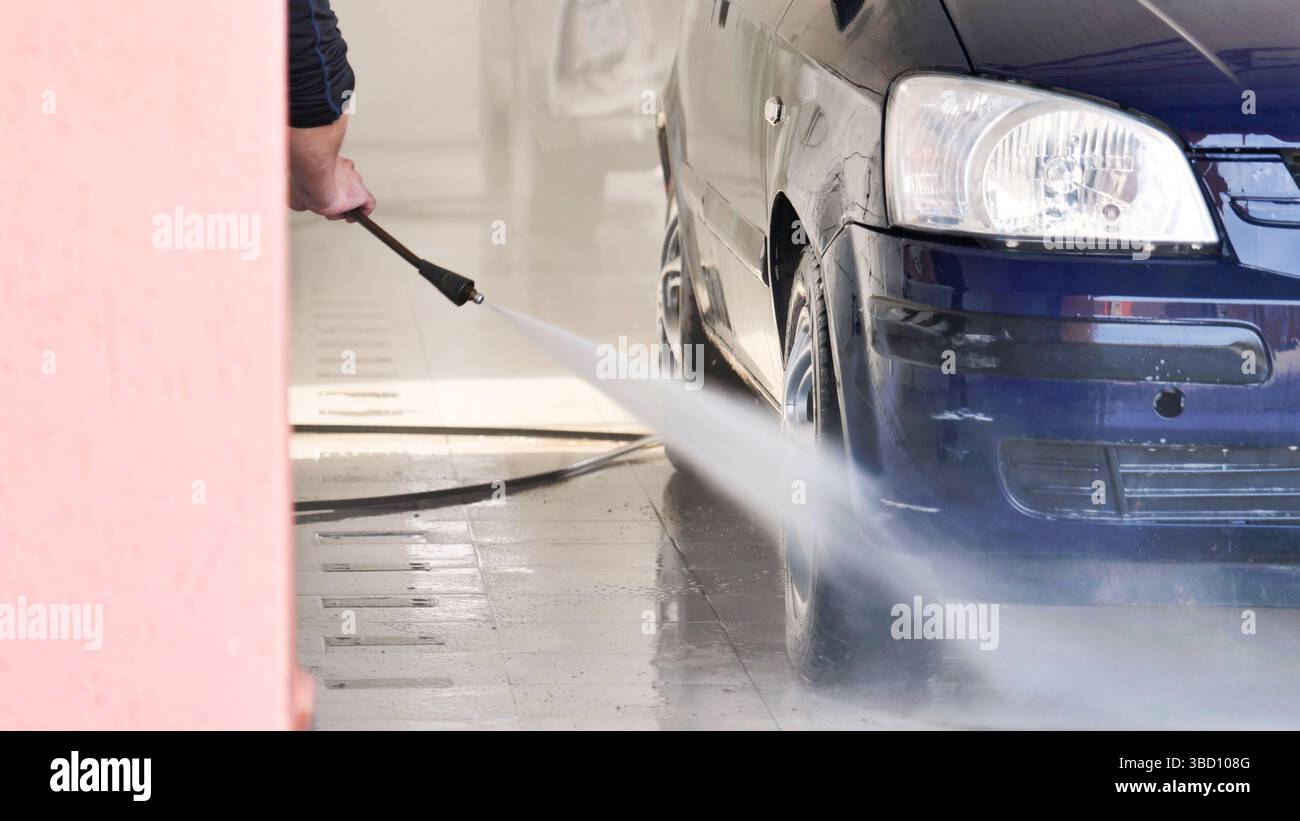 Car wash worker using high pressure water jet cleaning vehicle Stock ...