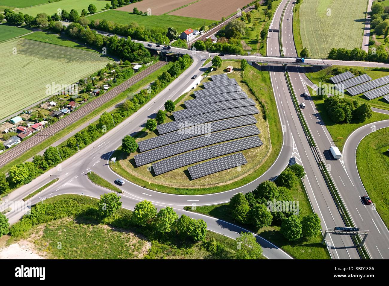 Aerial drone shot of photovoltaic solar panels next to a highway access ...