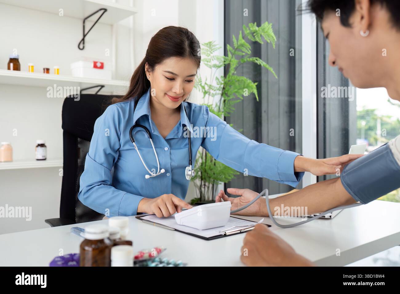 Health and Wellness. Doctor measuring blood pressure during a routine ...