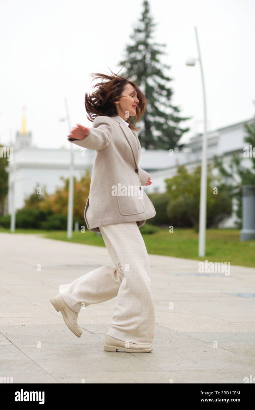 Captured in mid-twirl, a confident woman shows her coat lining while ...