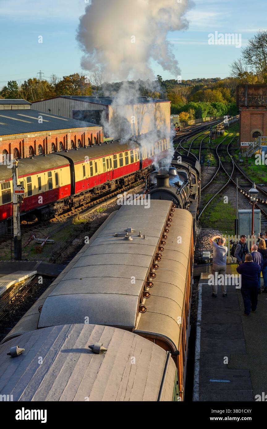 A steam locomotive shunts passenger carriages on Bluebell Railway Line ...