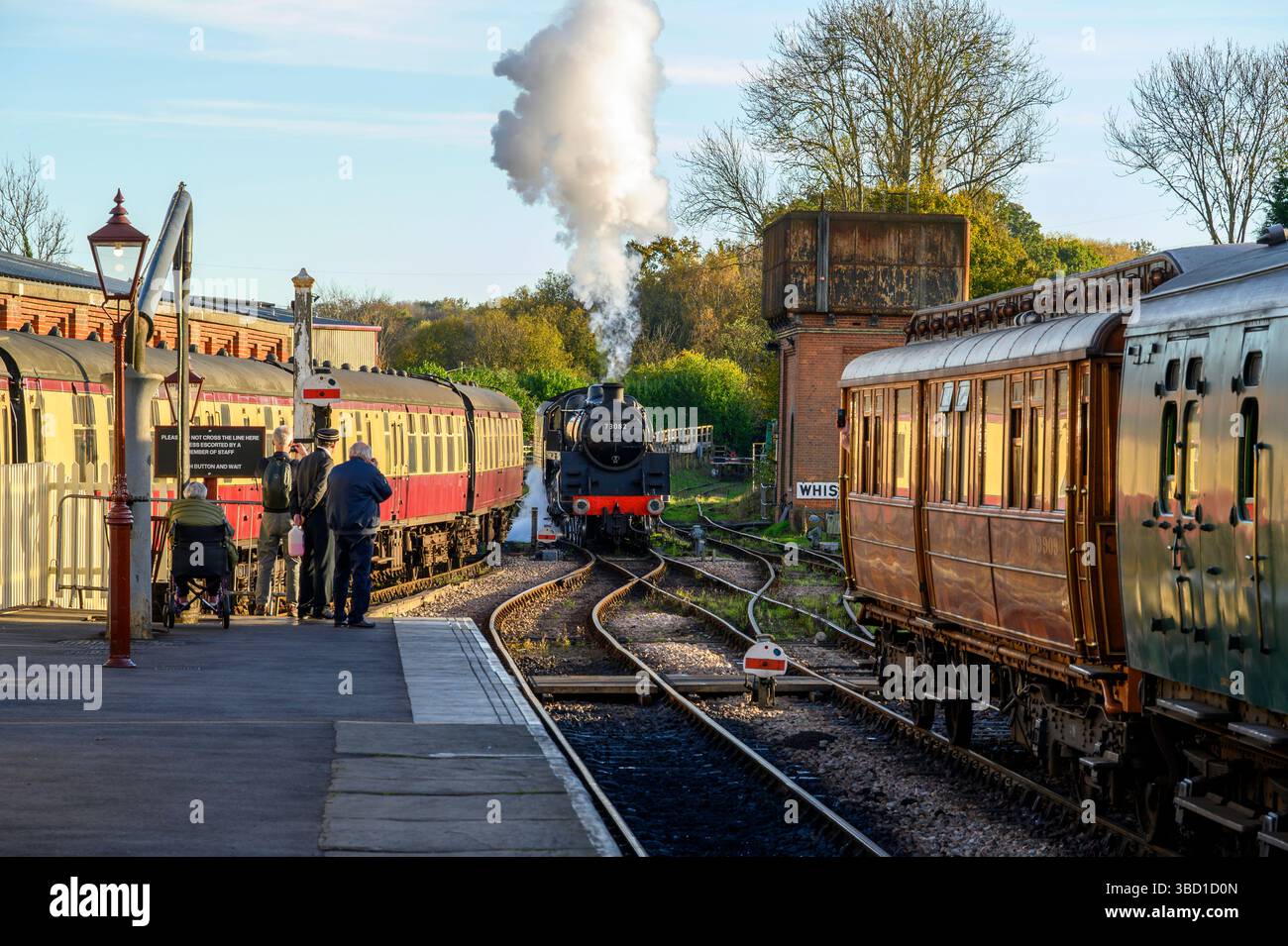 A group of people stand on a platform at Sheffield Park station ...