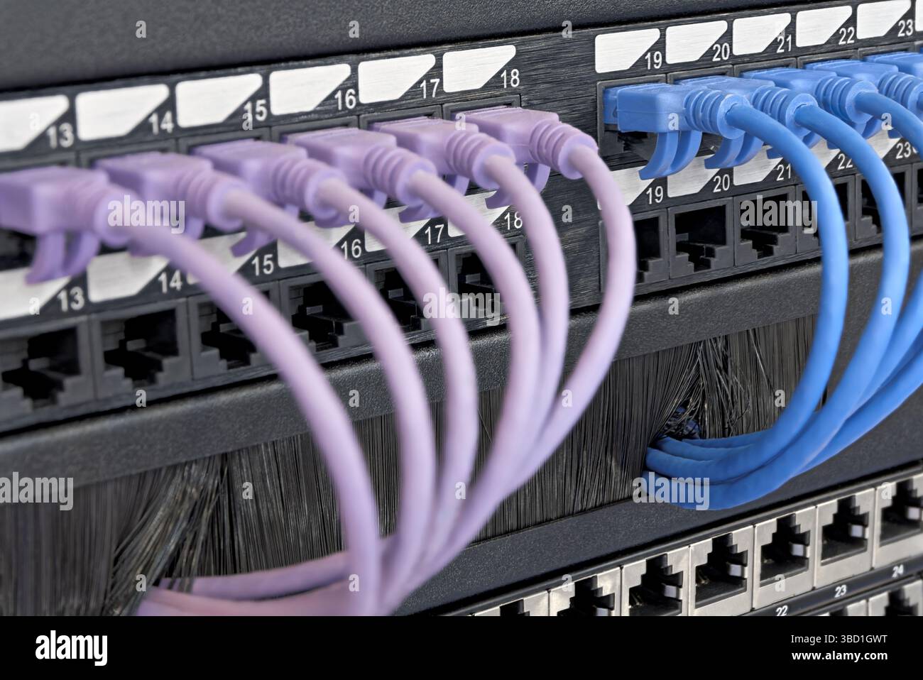 Data center, network panel, switch and connected multi-colored cables ...