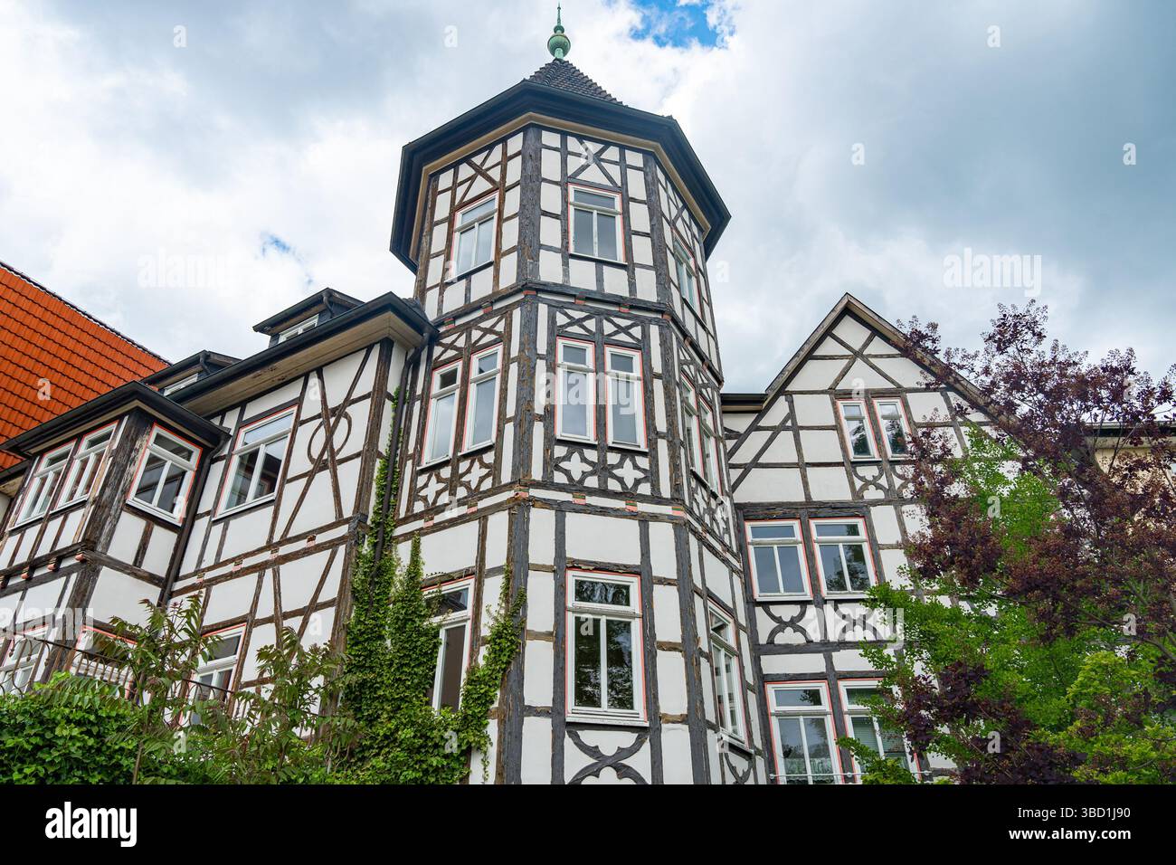 Traditional half-timbered house featuring a distinctive tower and lush ...