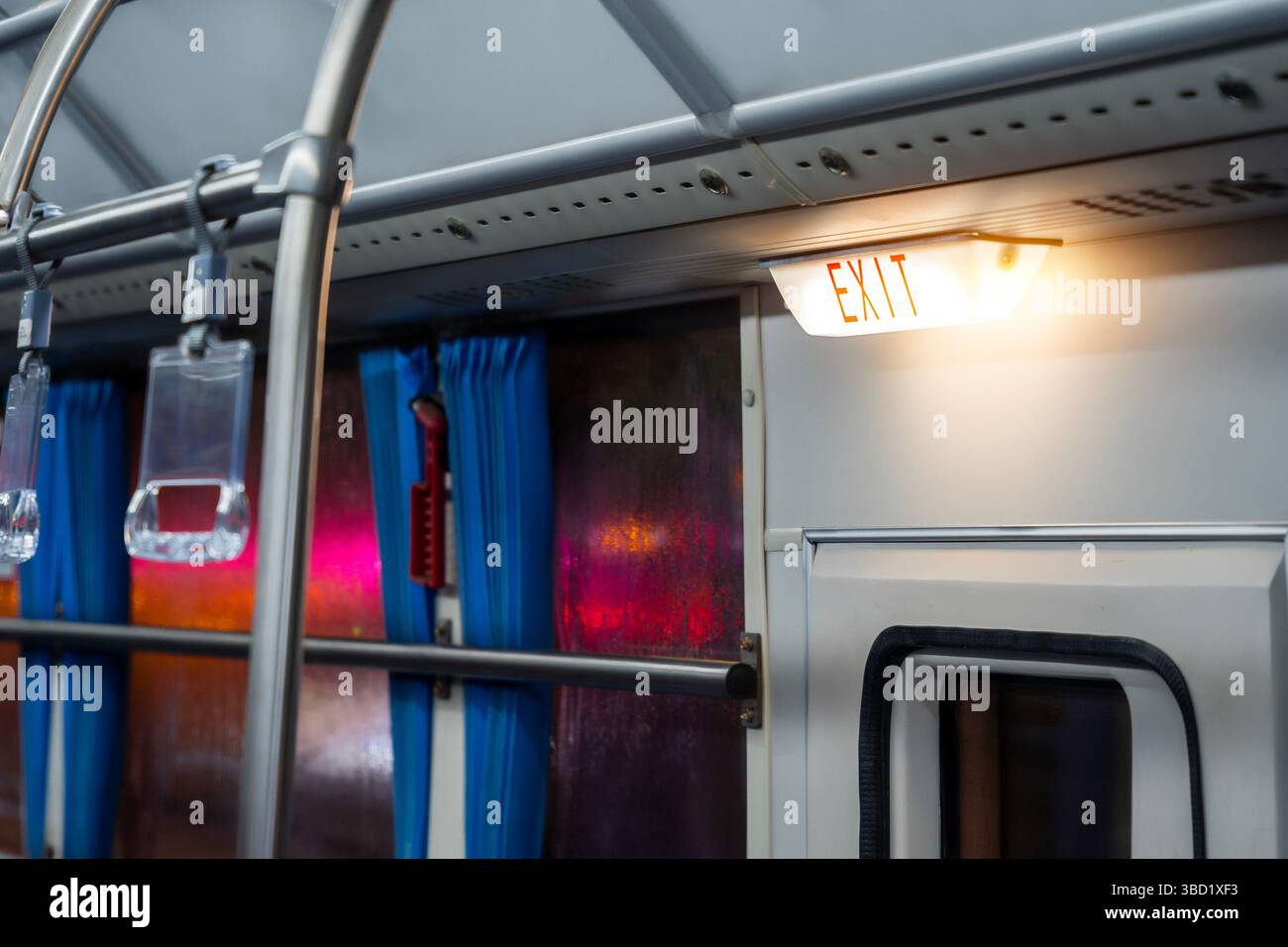 The emergency exit sign inside of bus or train with curtains and window ...