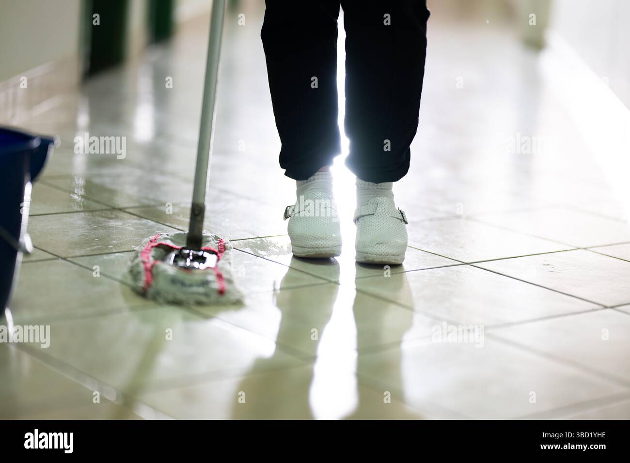 Cleaning Staff in Hospital Hallway.Female janitor standing in a hospital corridor with mop and ...