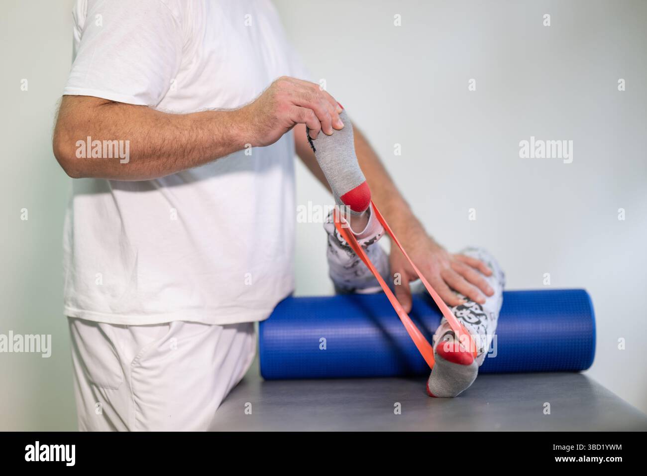 Leg Resistance Band Therapy.Therapist assisting with leg stretching ...
