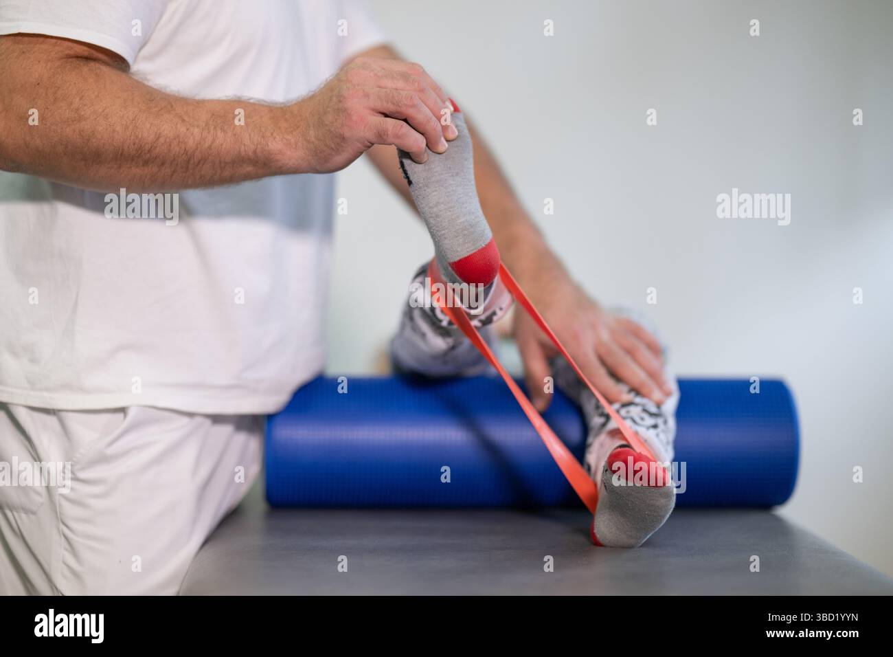Leg Resistance Band Therapy.Therapist assisting with leg stretching ...