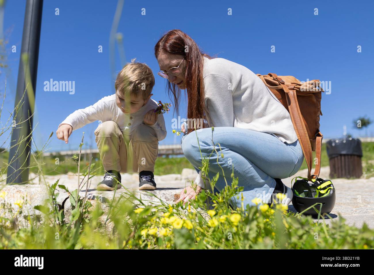 Mother and son discovering nature, observing plants and flowers in ...