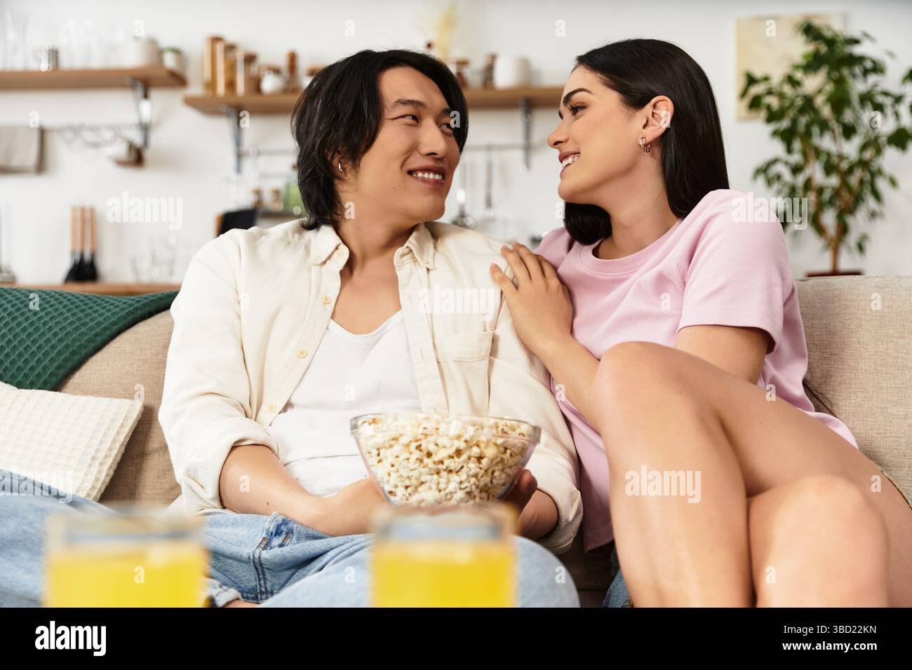 A man and woman share a tender moment on the couch while enjoying ...