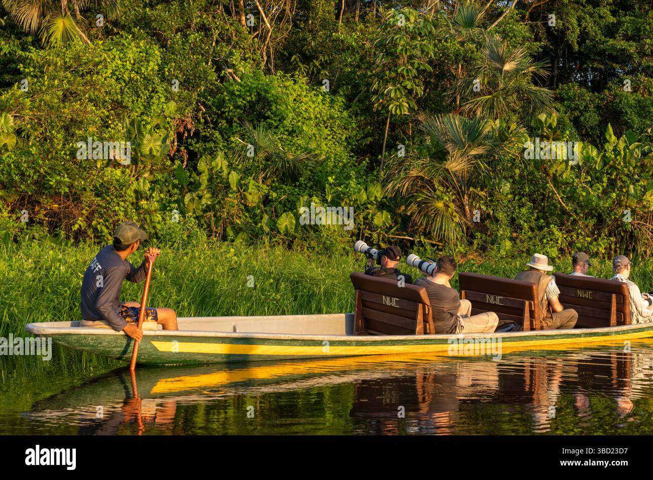 Photographers on a wildlife-spotting tour in a canoe in the Napo ...
