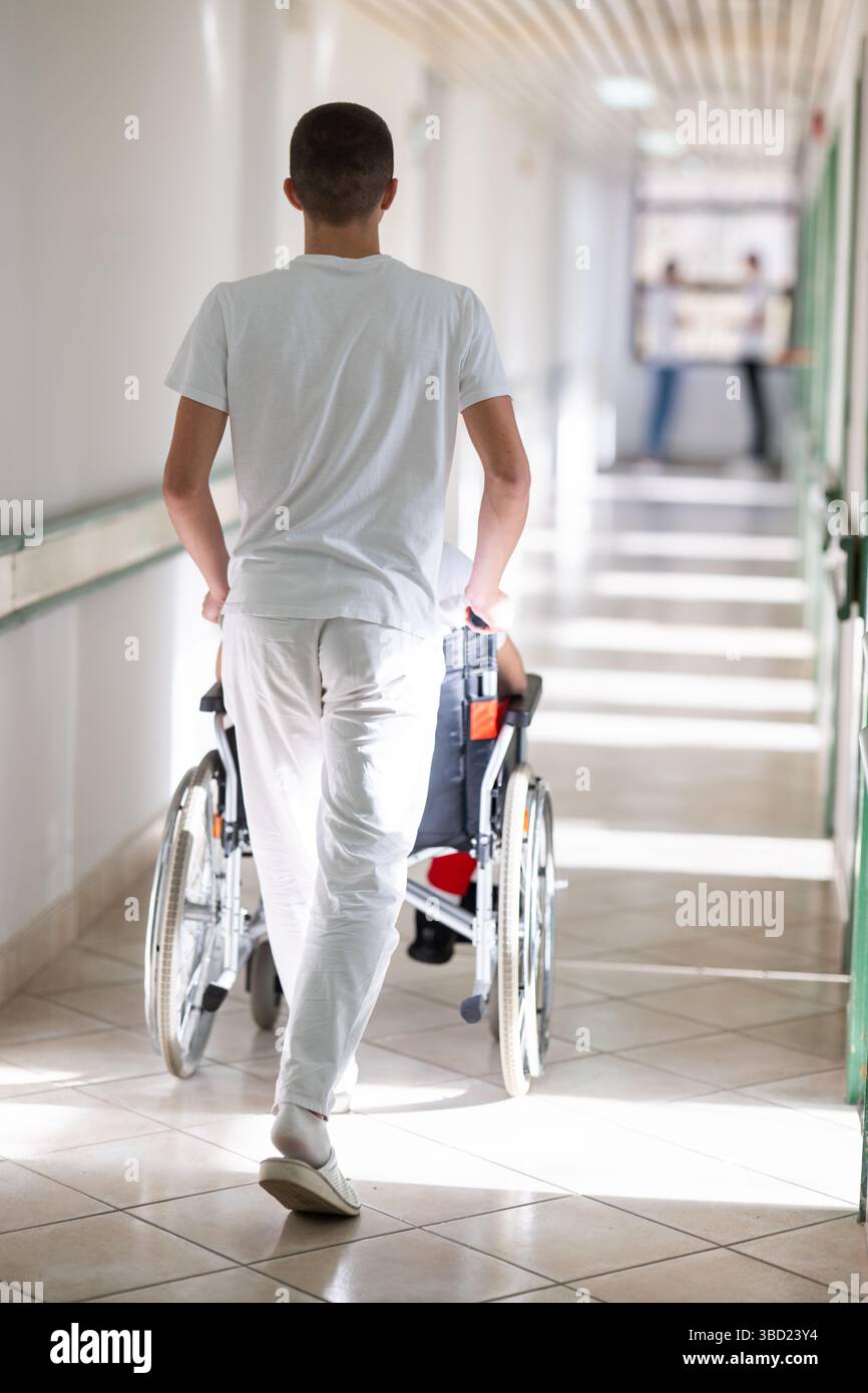 Hospital Staff with Wheelchair in Hallway Stock Photo - Alamy