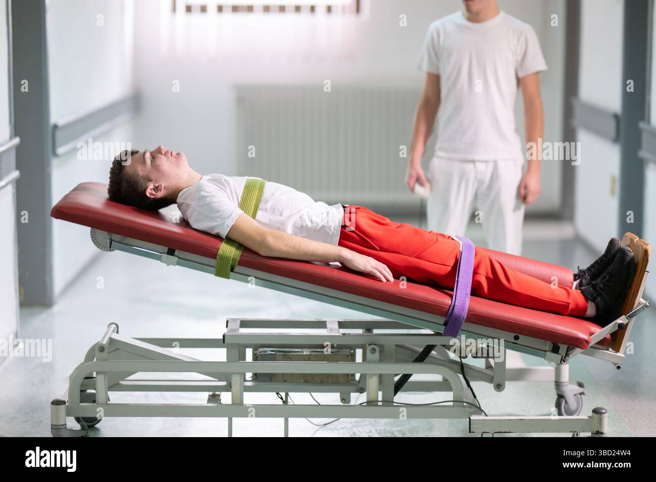 Rehabilitation with Standing Frame.Male therapist assists patient with ...