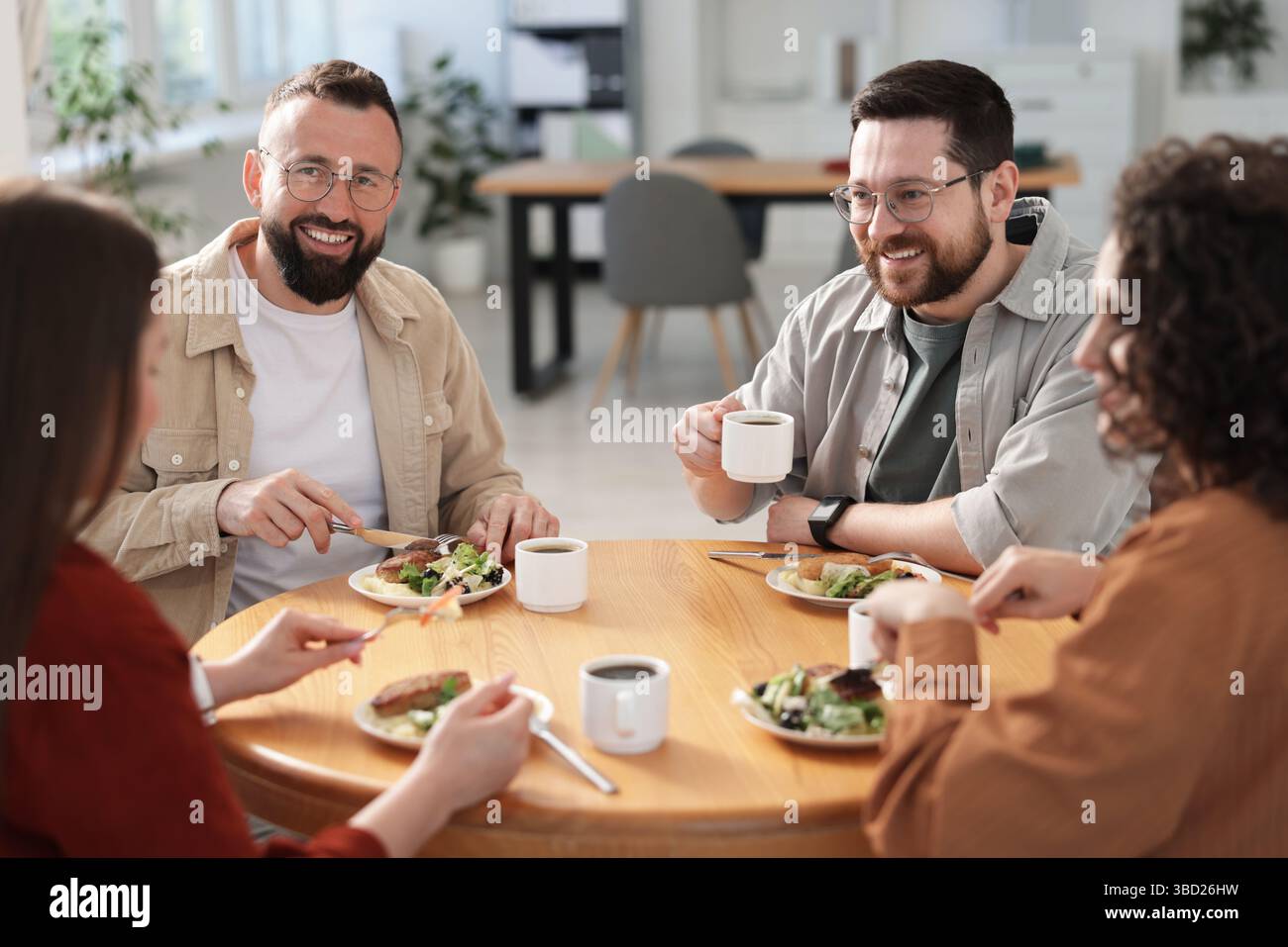 Colleagues chatting during lunch break in office Stock Photo - Alamy