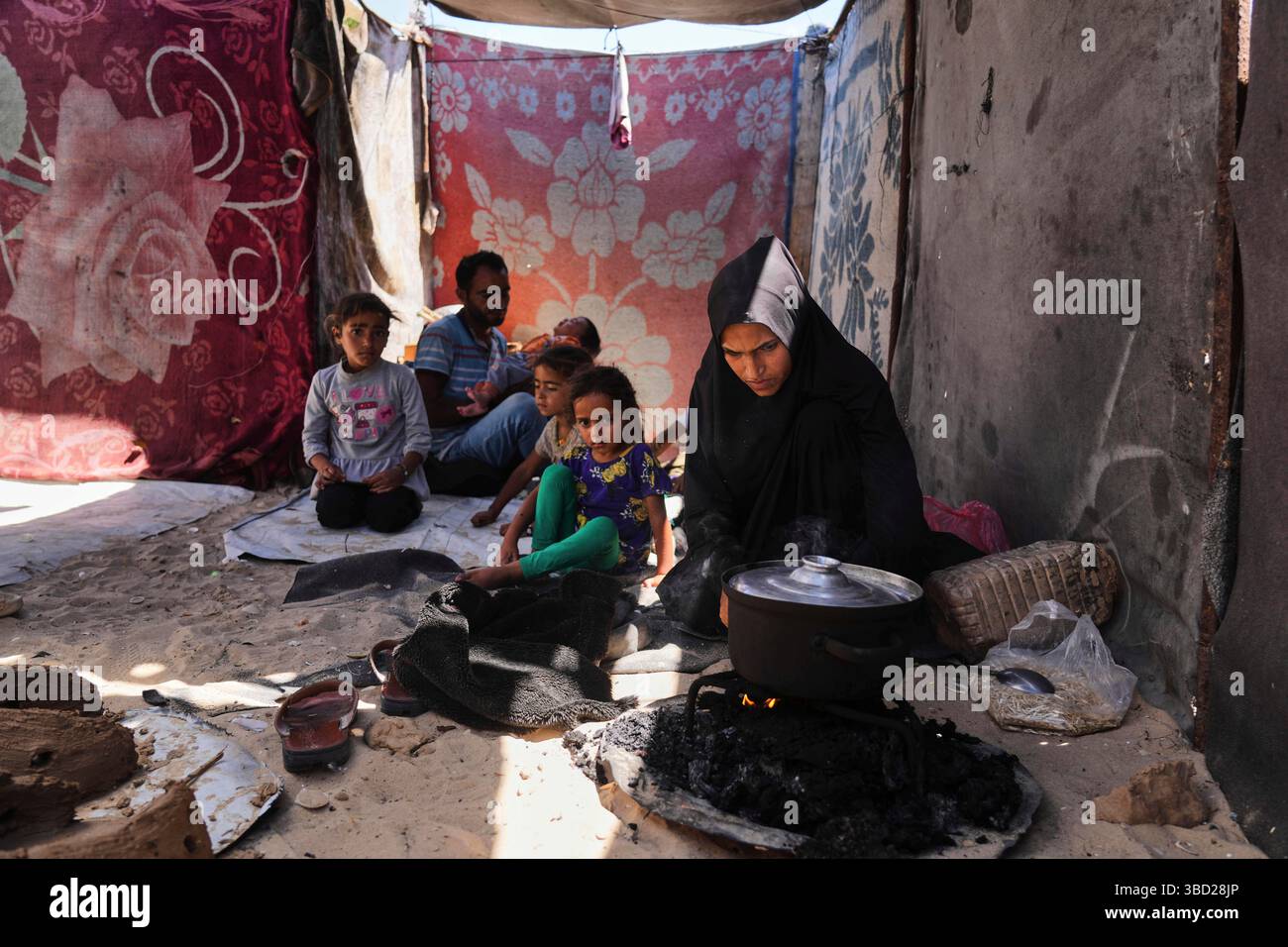 Nouf Al-Arja, 30, who suffers from malnutrition, cooks for her family ...