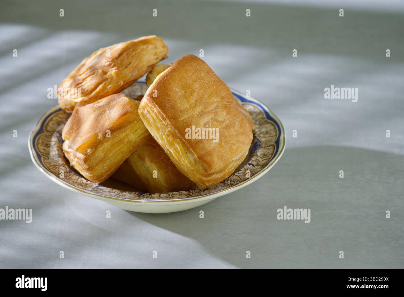 Baked square puff pastries on a decorated plate, showcasing their ...