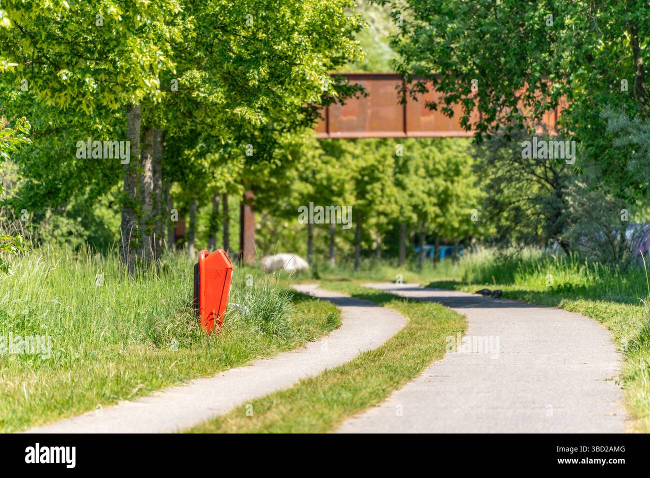 Path with Red Trash Can. A narrow cycle and pedestrian path winds ...