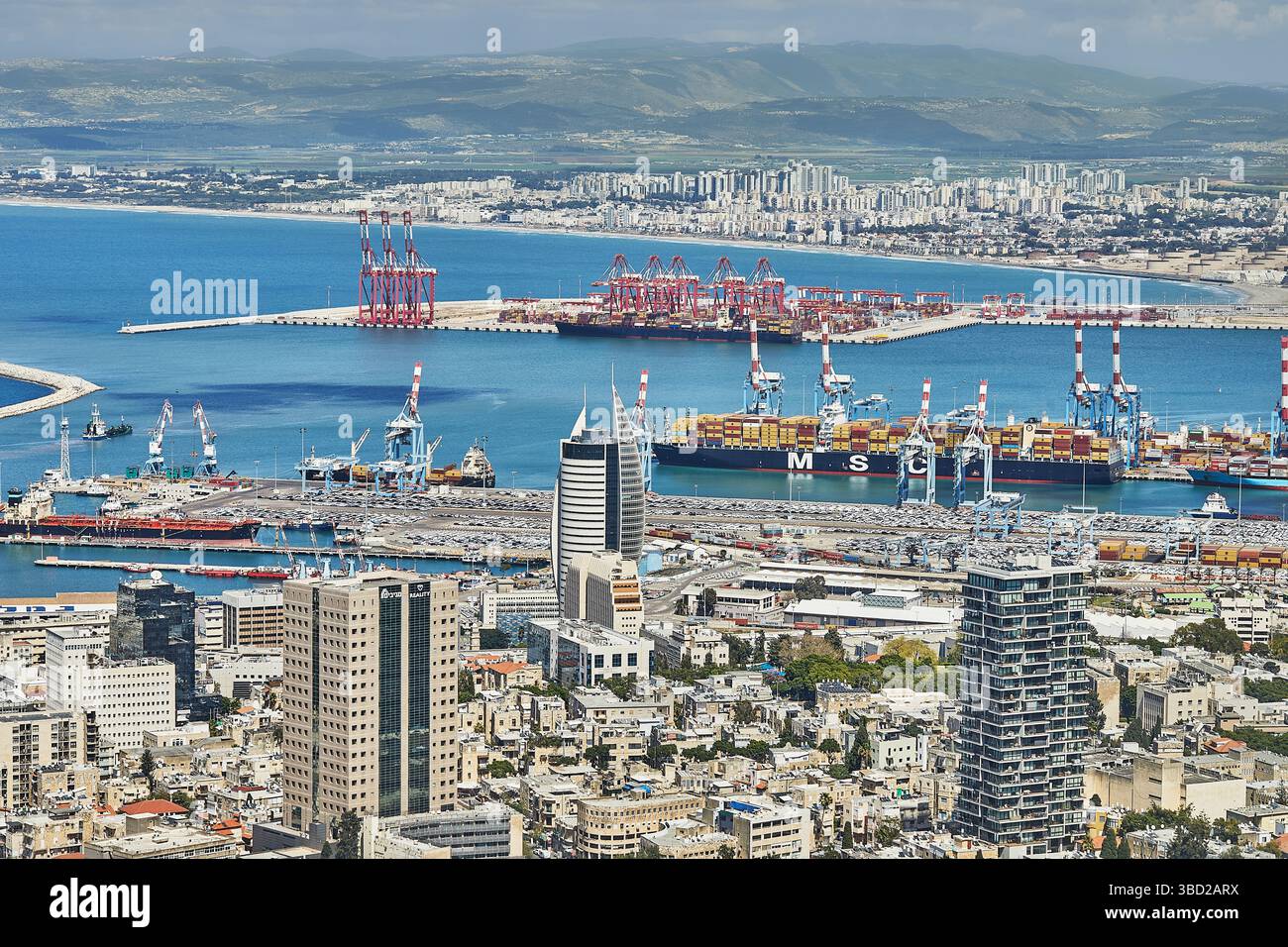 Numerous cargo ships anchored off the coast of Haifa, Israel under a ...