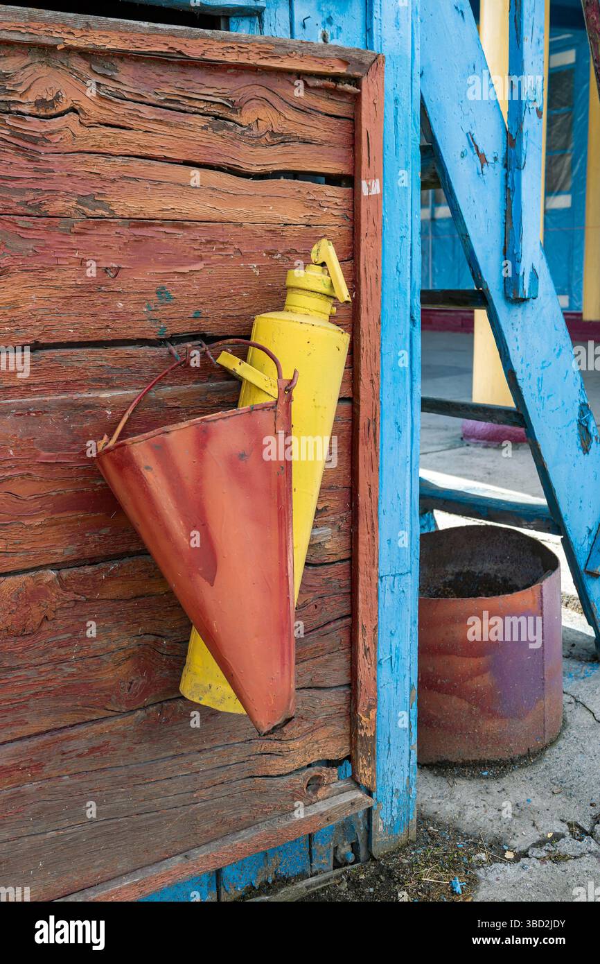 Outdated fire shield with red cone bucket and yellow fire extinguisher ...