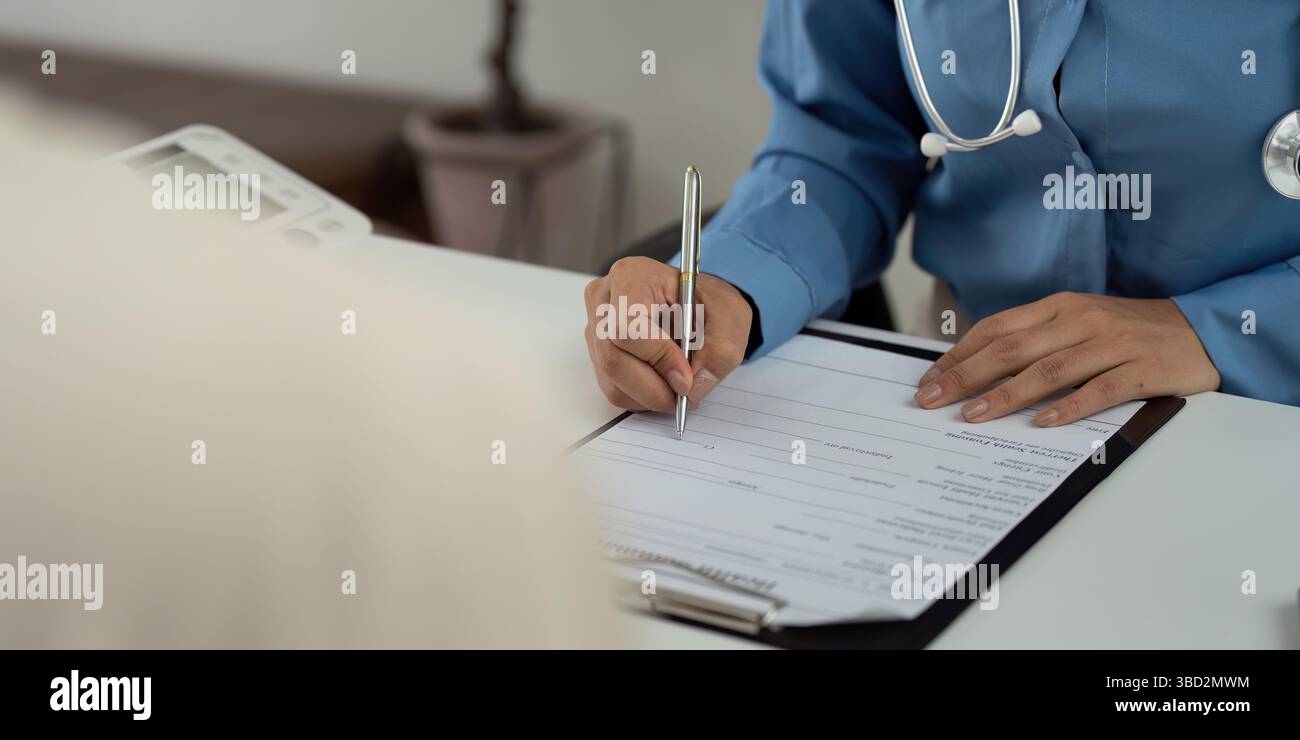 Health and Wellness. Doctor taking patient notes during consultation ...