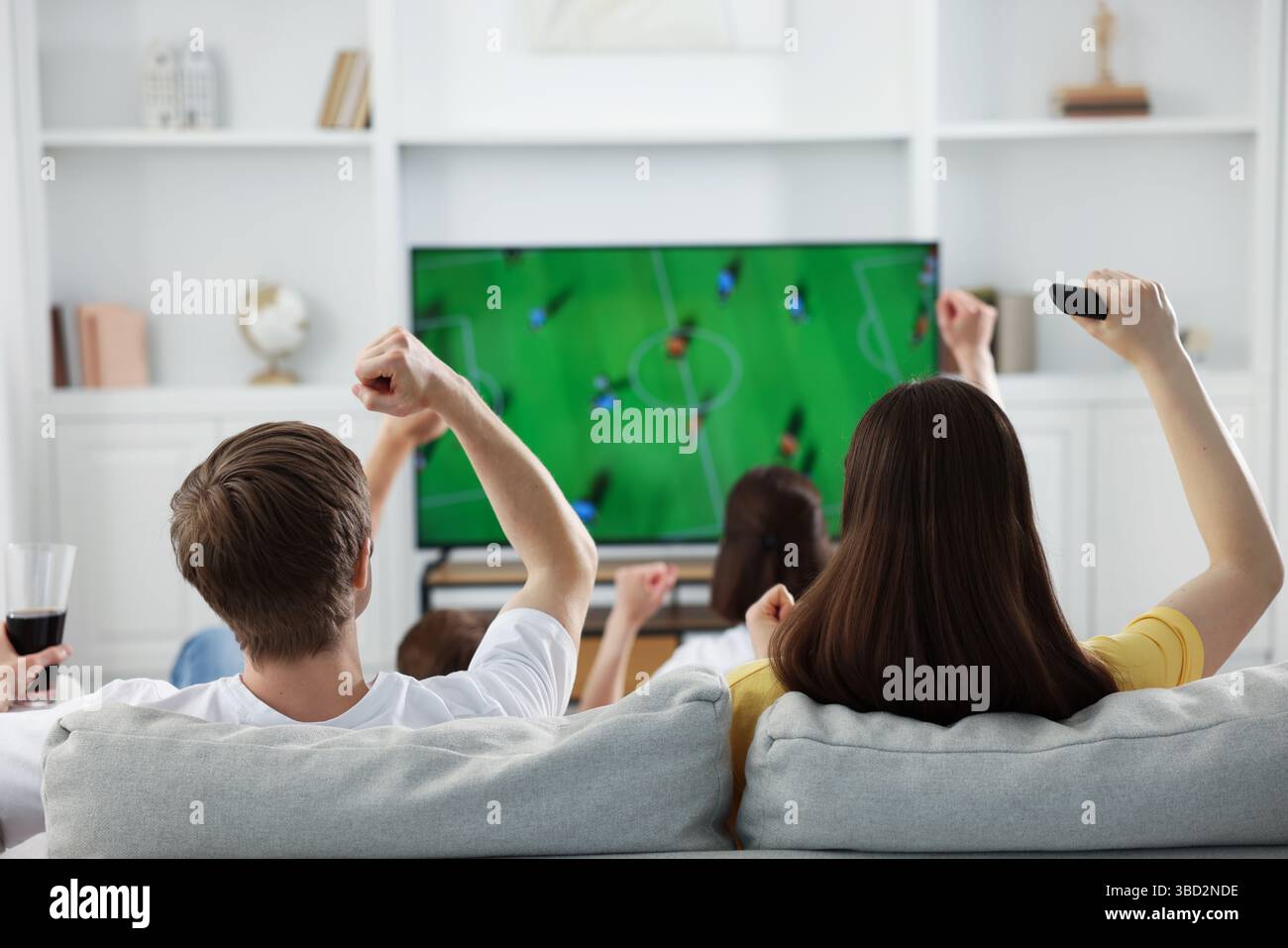 Group of football fans watching game together indoors, back view Stock ...