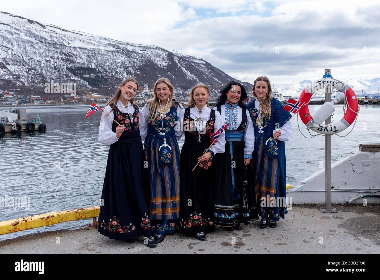 Girls in traditional Norwegian dress (bunad) waving Norwegian flags on ...