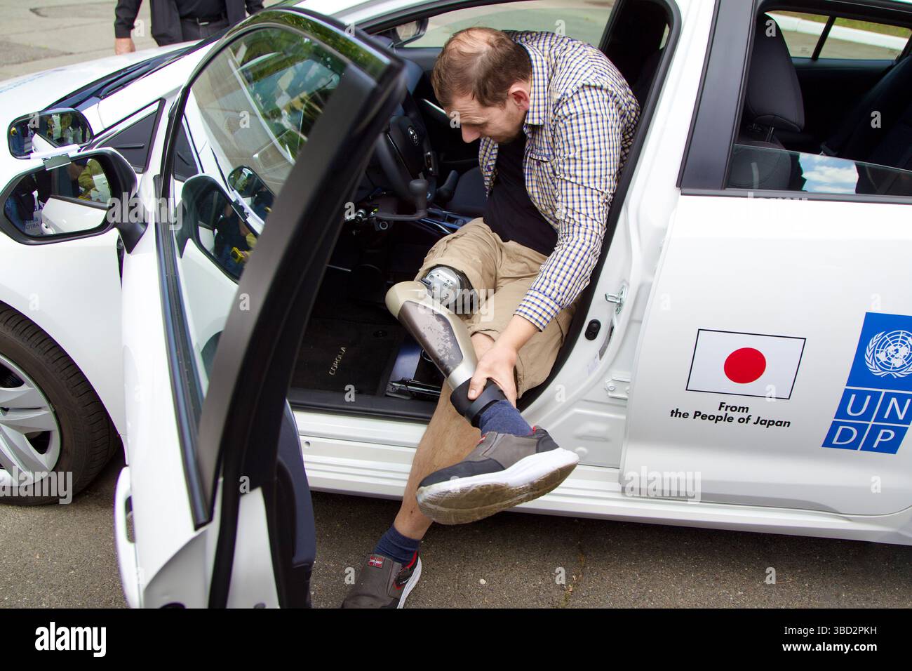 A driver with a prosthetic leg is seen behind the wheel of an adapted ...