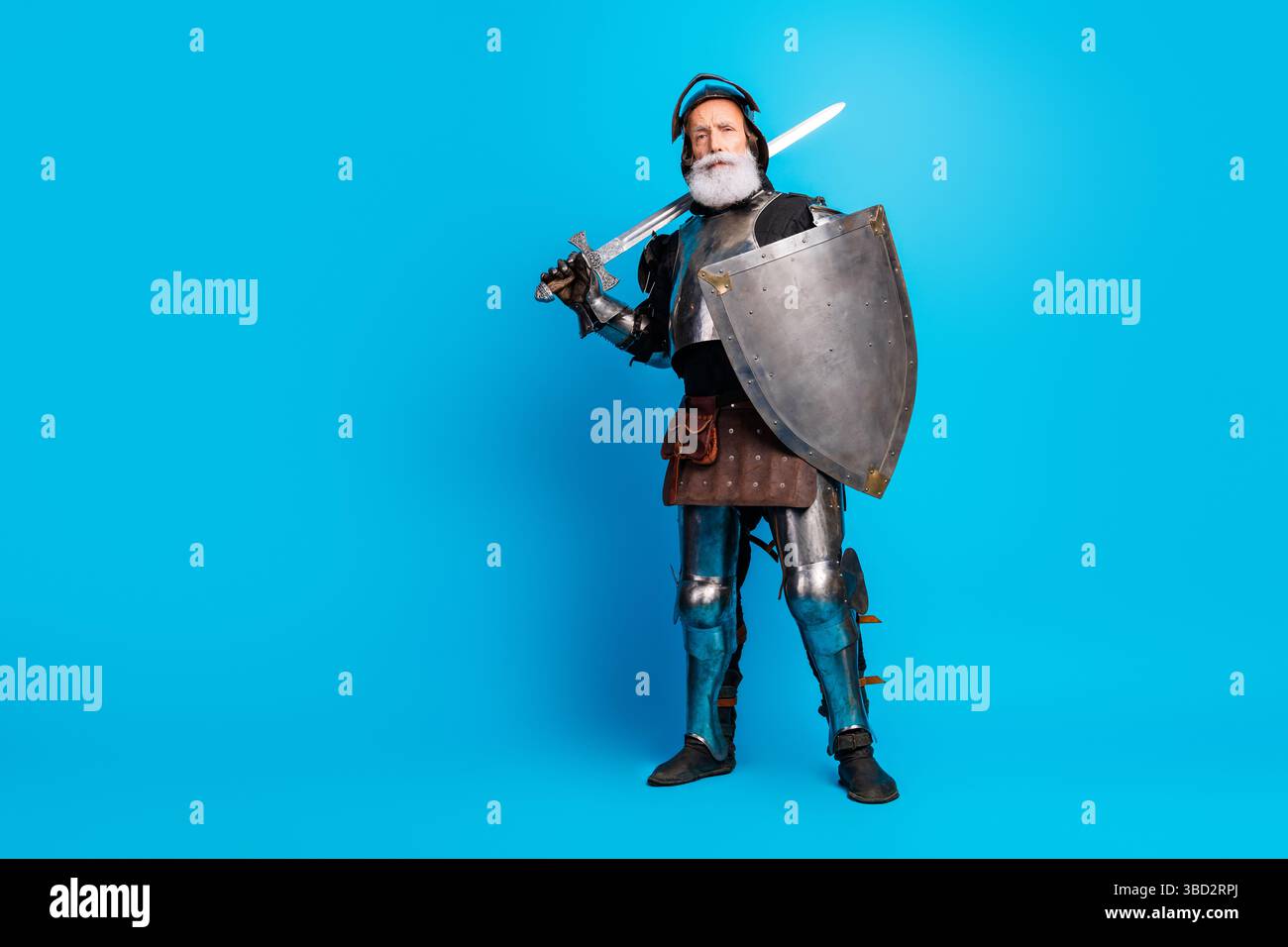 Elderly man dressed as a knight in medieval armor with sword and shield ...