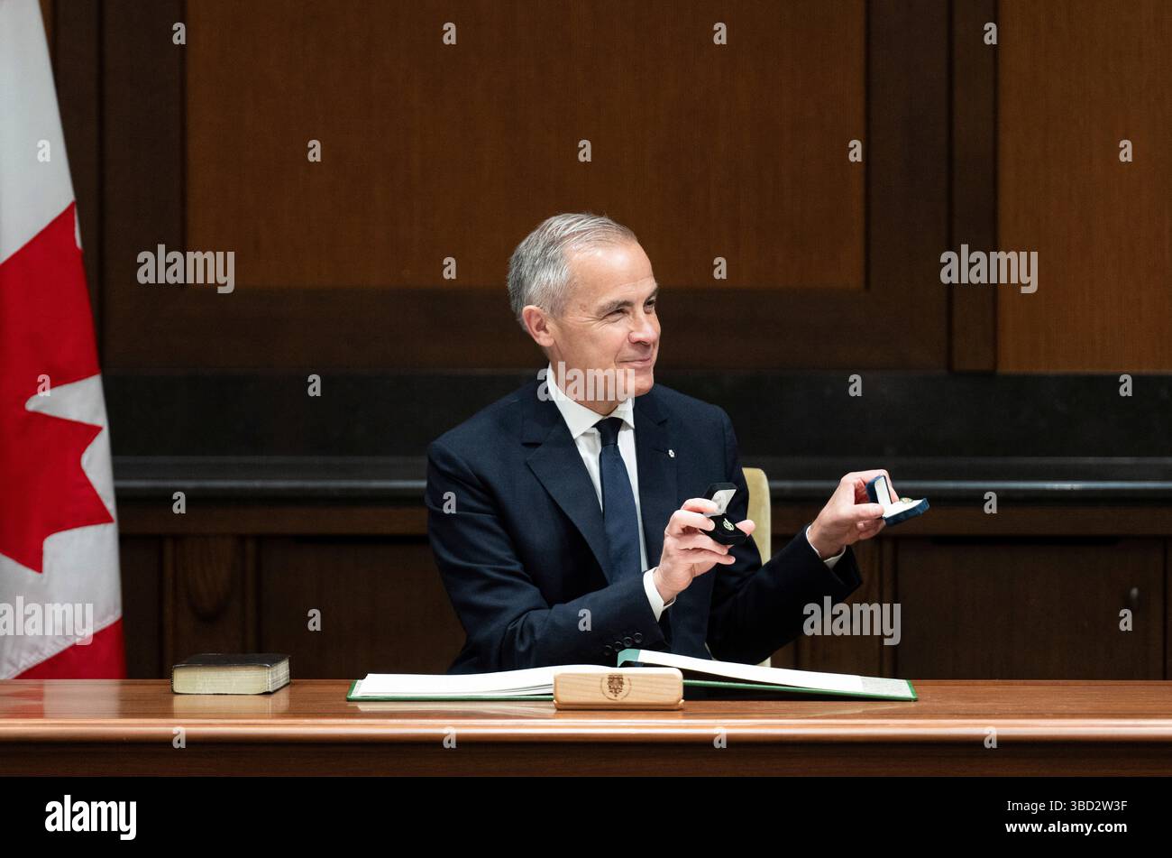 Canada Prime Minister Mark Carney shows off a pair of lapel pins given ...