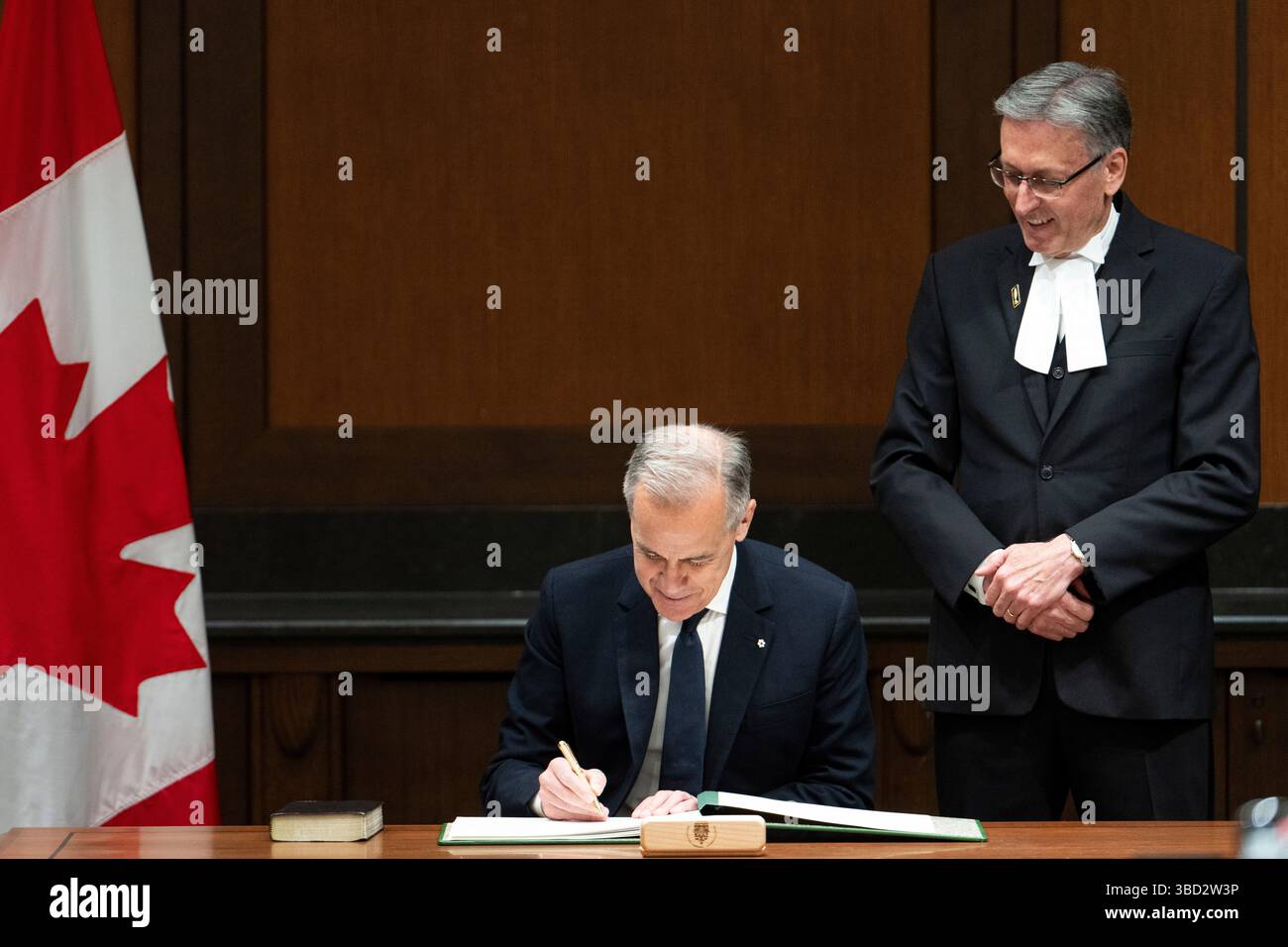 Canada Prime Minister Mark Carney signs a document as he is sworn-in as ...